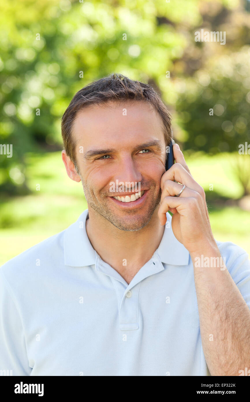 Handsome man phoning in the park Stock Photo - Alamy