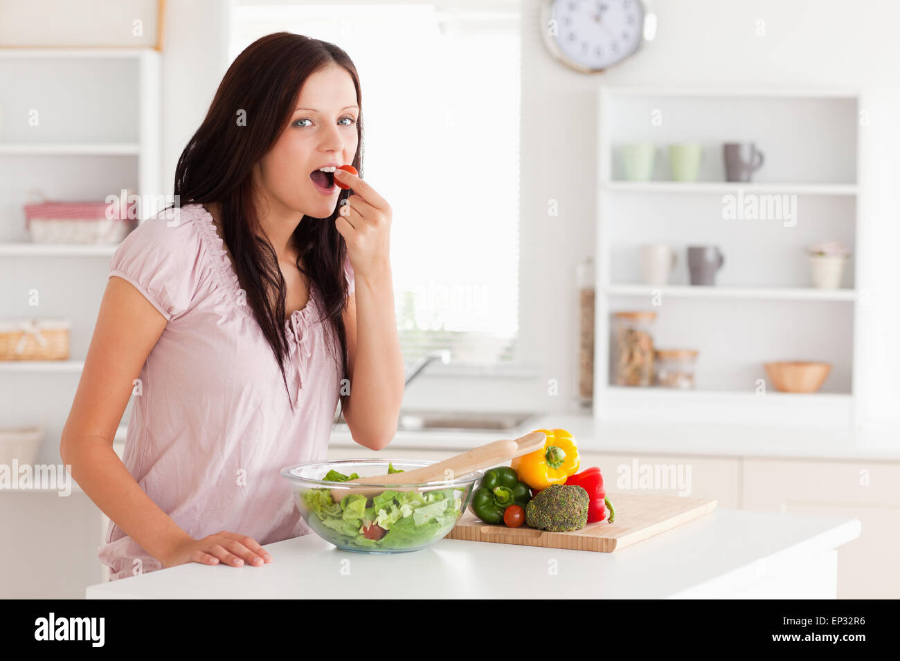 Cute woman eating vegetables Stock Photo - Alamy