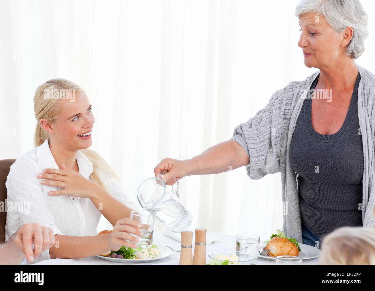 Aged woman serving her daughter Stock Photo - Alamy