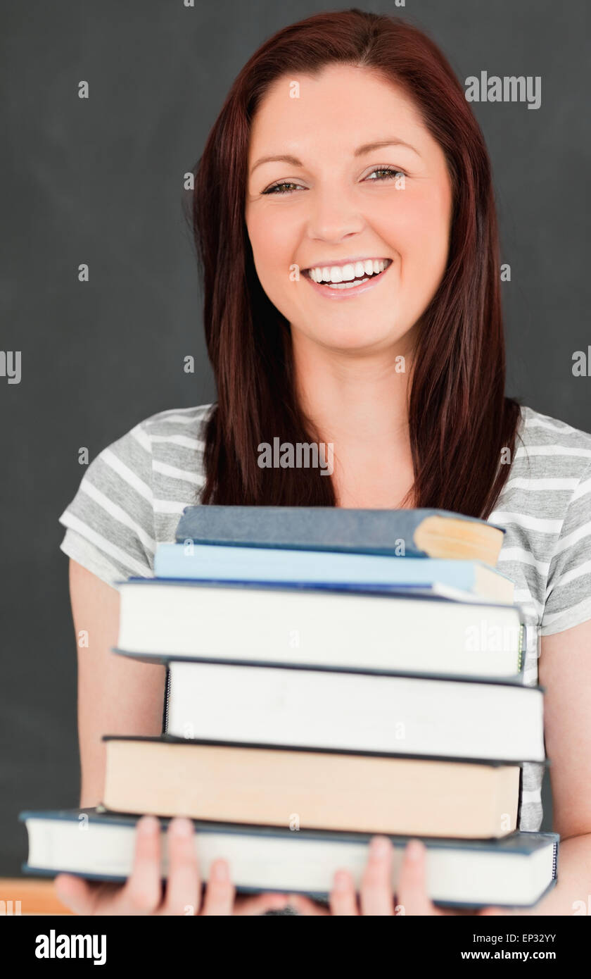 Laughing young woman bringing books Stock Photo - Alamy
