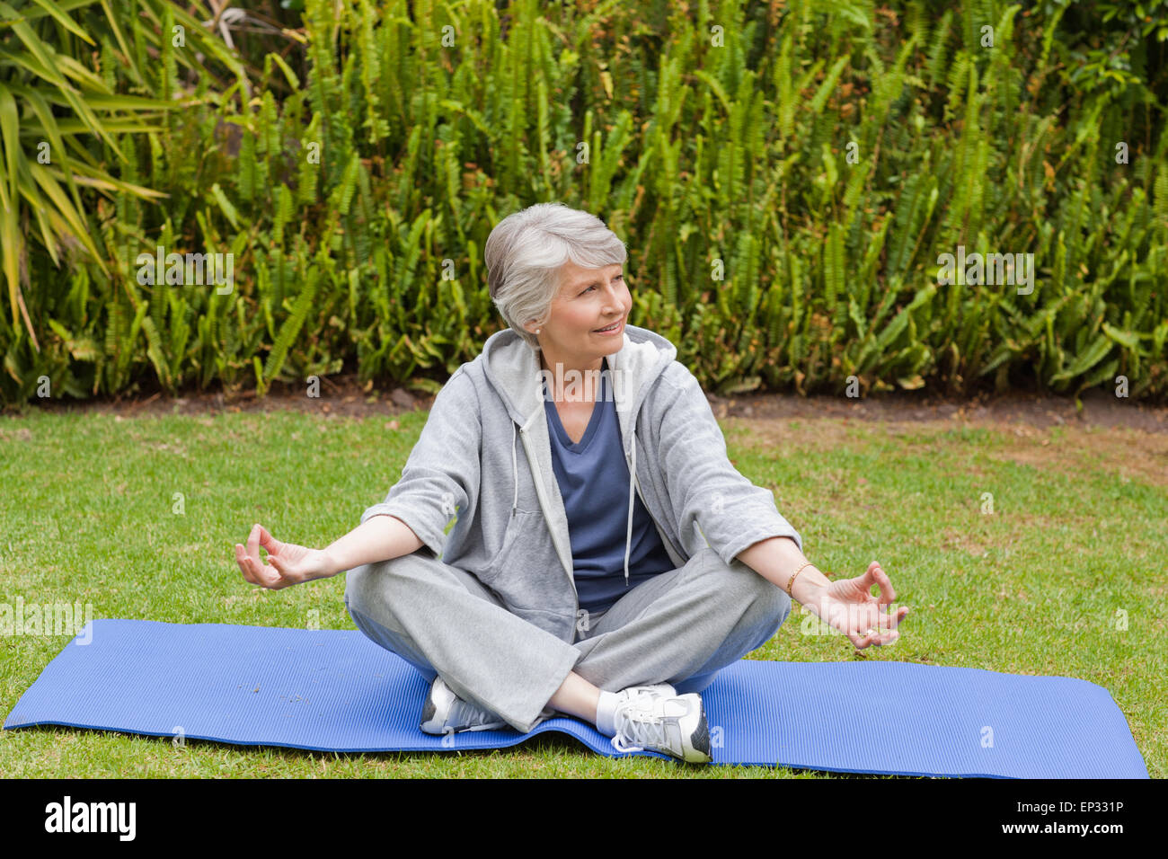 Retired woman practicing yoga in the garden Stock Photo - Alamy