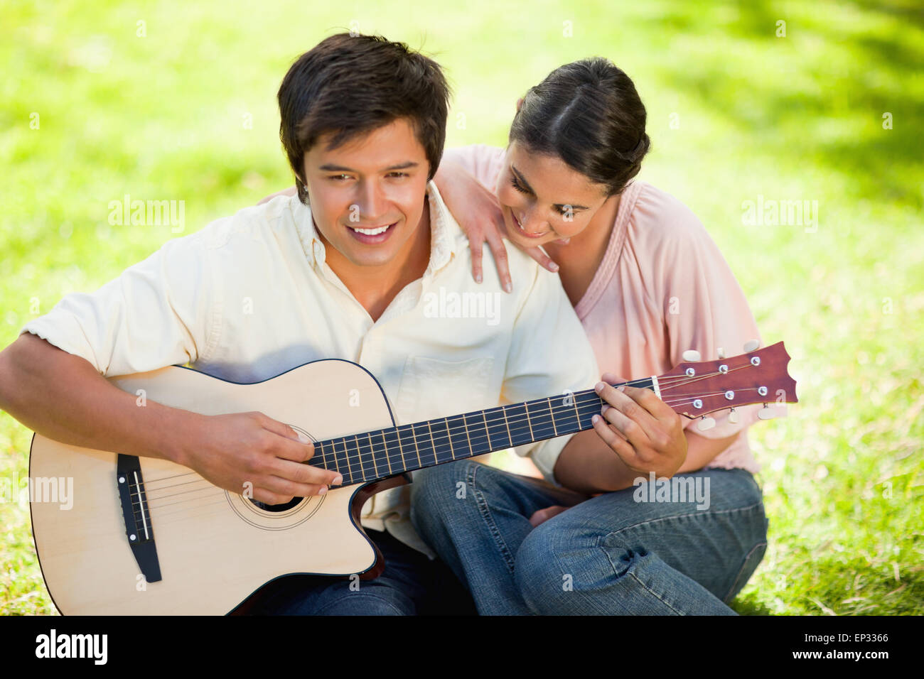 Woman leaning while leaning on her friends shoulder as he plays the ...