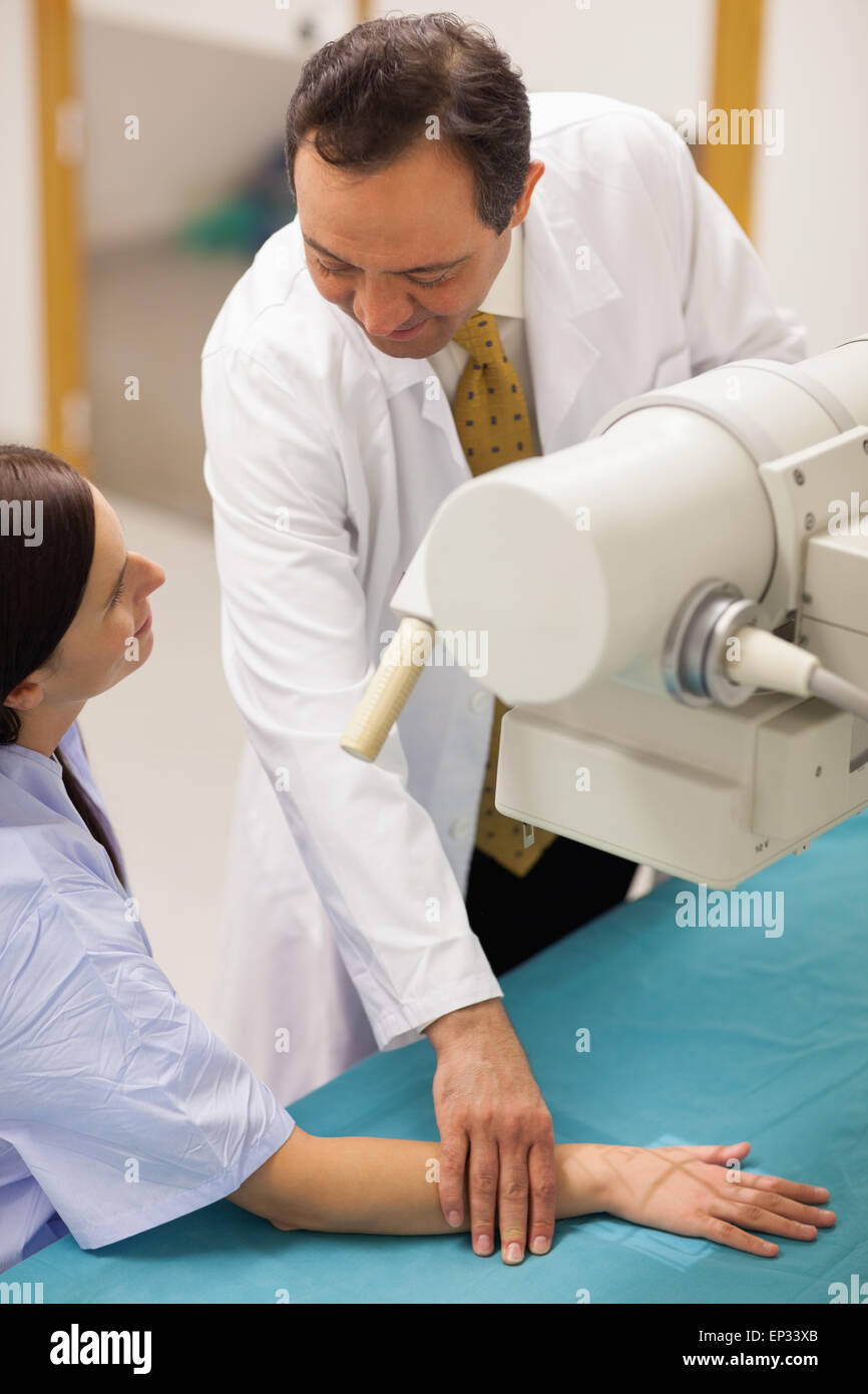 Smiling doctor placing the arm of a patient on a table Stock Photo - Alamy