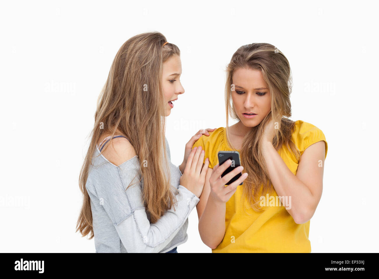 Upset Young Woman Holding Her Cellphone Consolded By Her Friend Stock