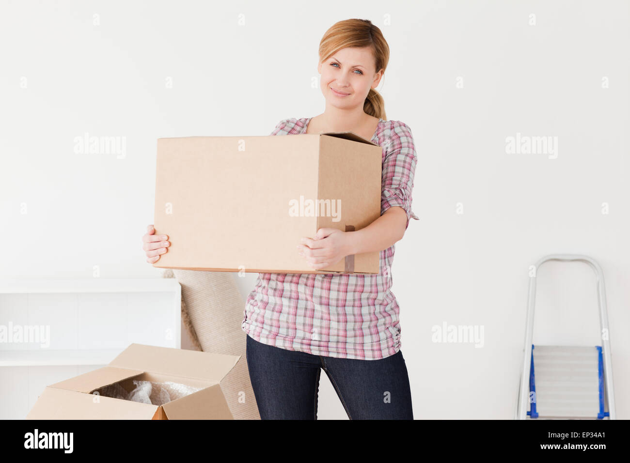 Blond-haired woman carrying cardboard boxes Stock Photo - Alamy