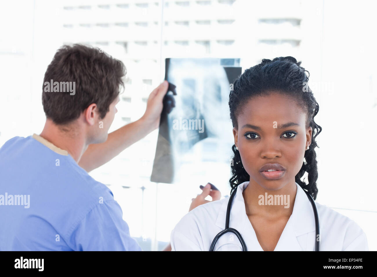 Male doctor looking at a of X-ray while his colleague is posing Stock ...