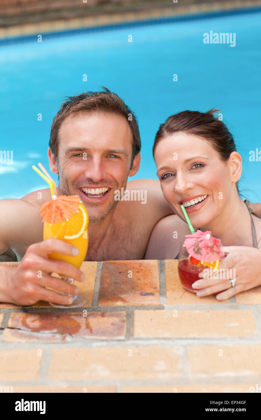 Beautiful couple drinking cocktails in the swimming pool Stock Photo ...