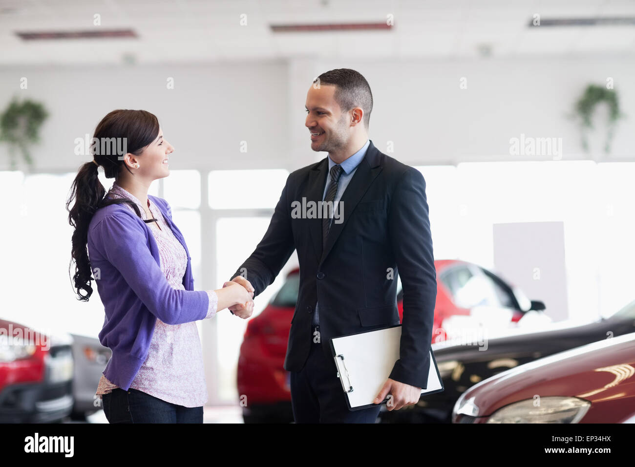 Smiling salesman shaking the hand of a woman Stock Photo - Alamy