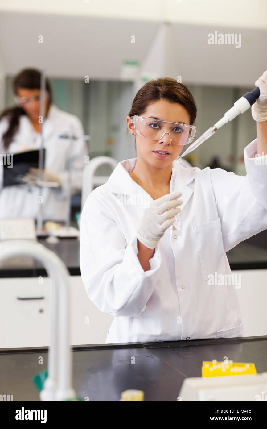 Portrait of a cute student pouring liquid in a tube Stock Photo - Alamy