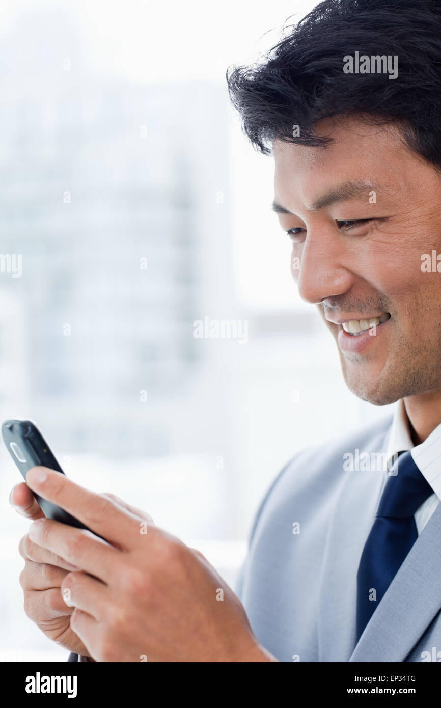 Portrait of a smiling office worker using his mobile phone Stock Photo ...