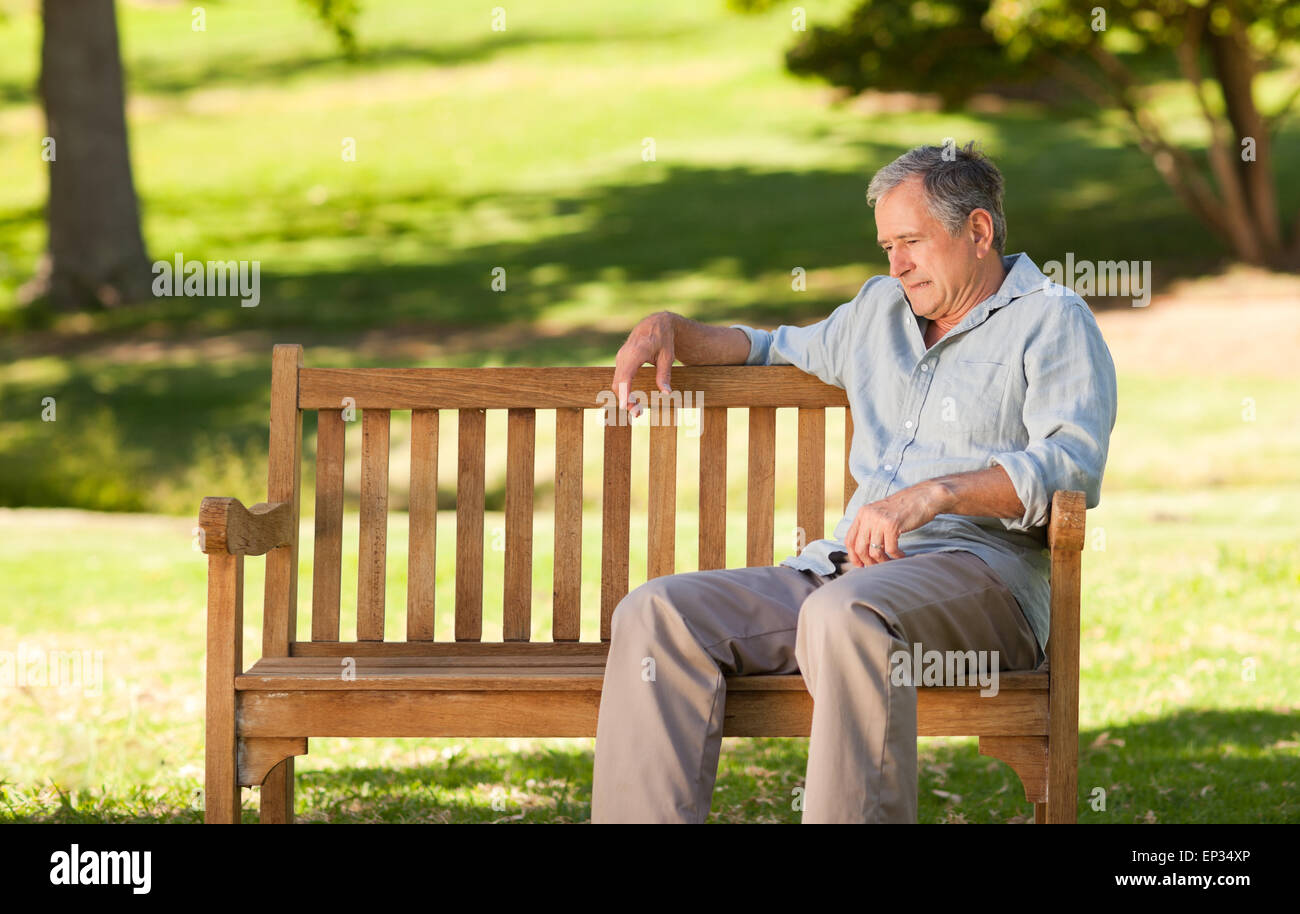 Elderly man sitting on a bench Stock Photo - Alamy