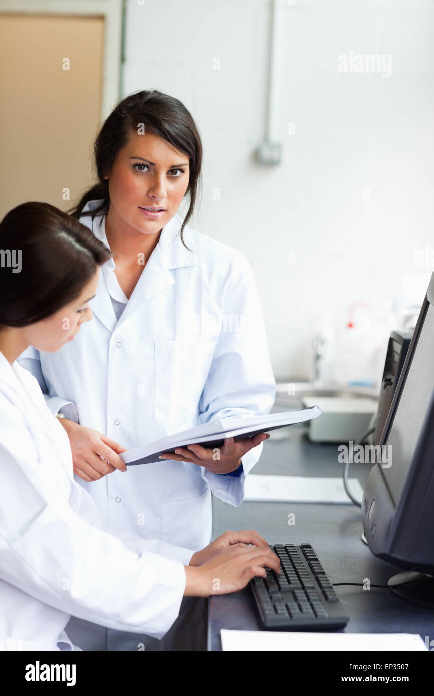 Portrait of cute scientists looking at a report Stock Photo - Alamy Portrait of cute scientists looking at a report Stock Photo - Alamy