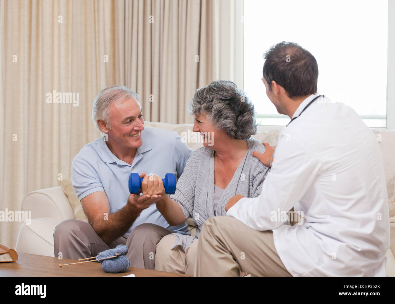 Handsome doctor helping his patient to do exercises Stock Photo - Alamy