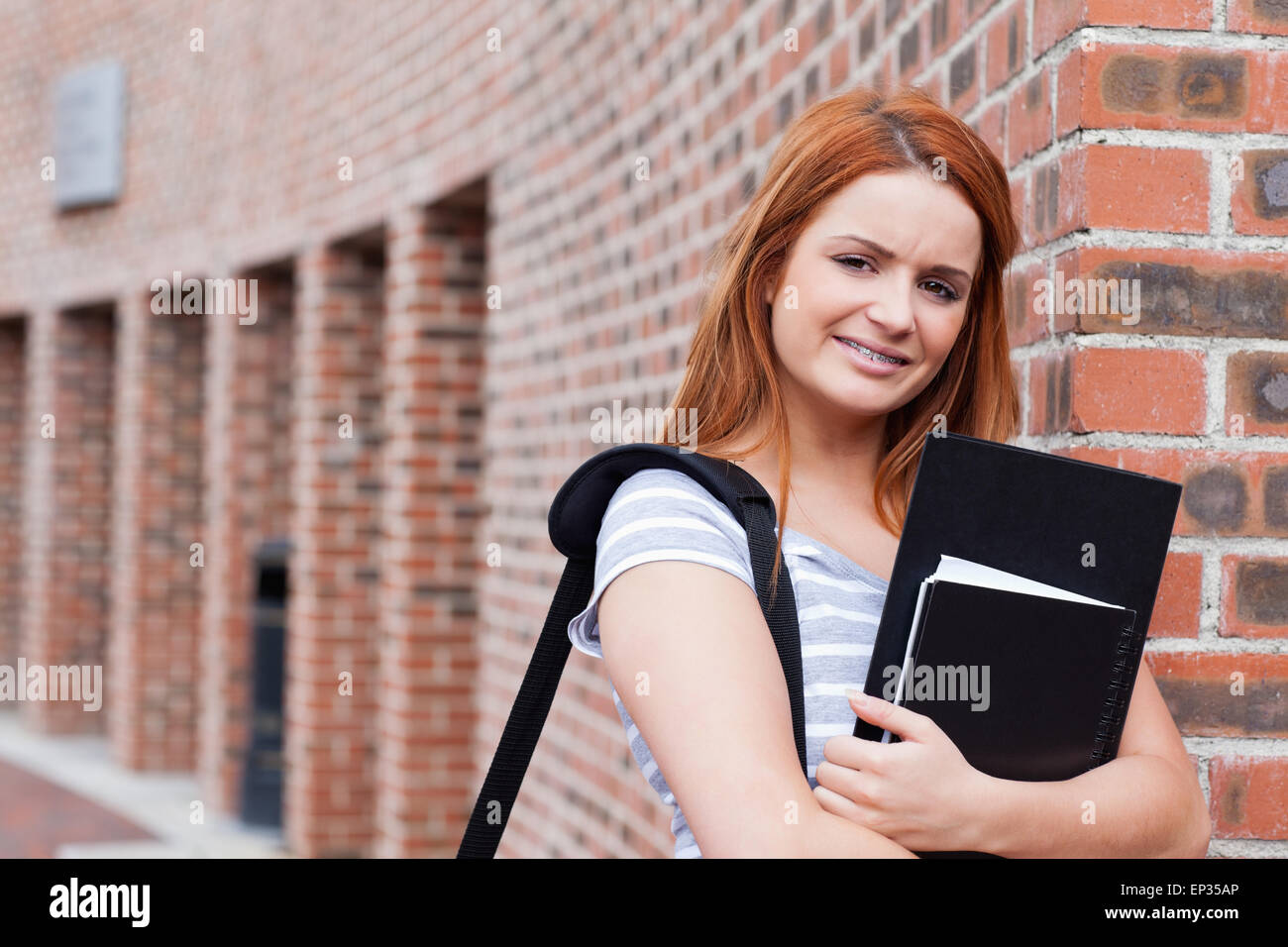 Smiling student holding her binder Stock Photo - Alamy