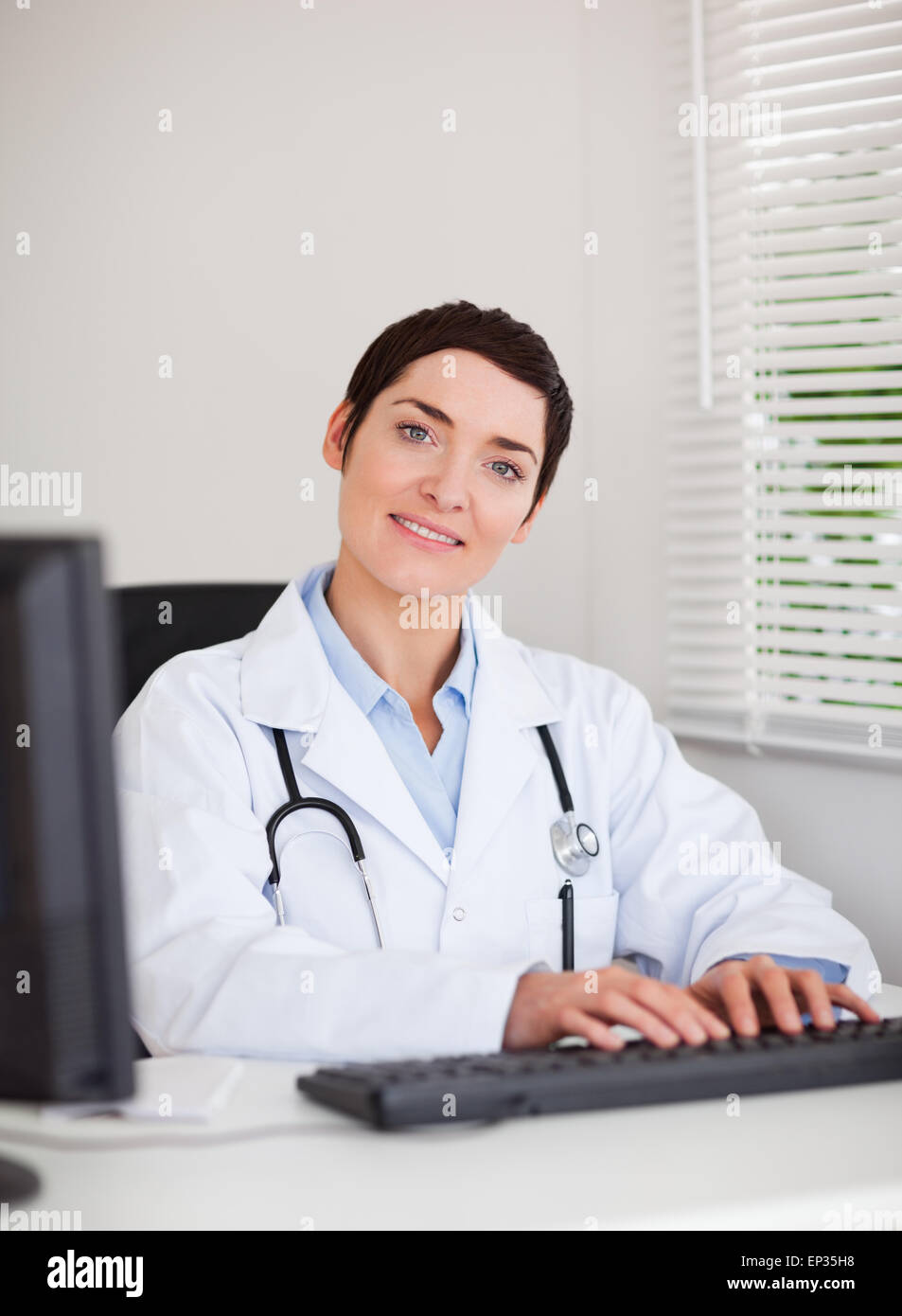 Portrait of a doctor typing with her computer Stock Photo - Alamy