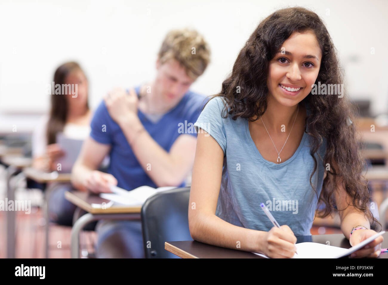 Smiling students working on an assignment Stock Photo - Alamy