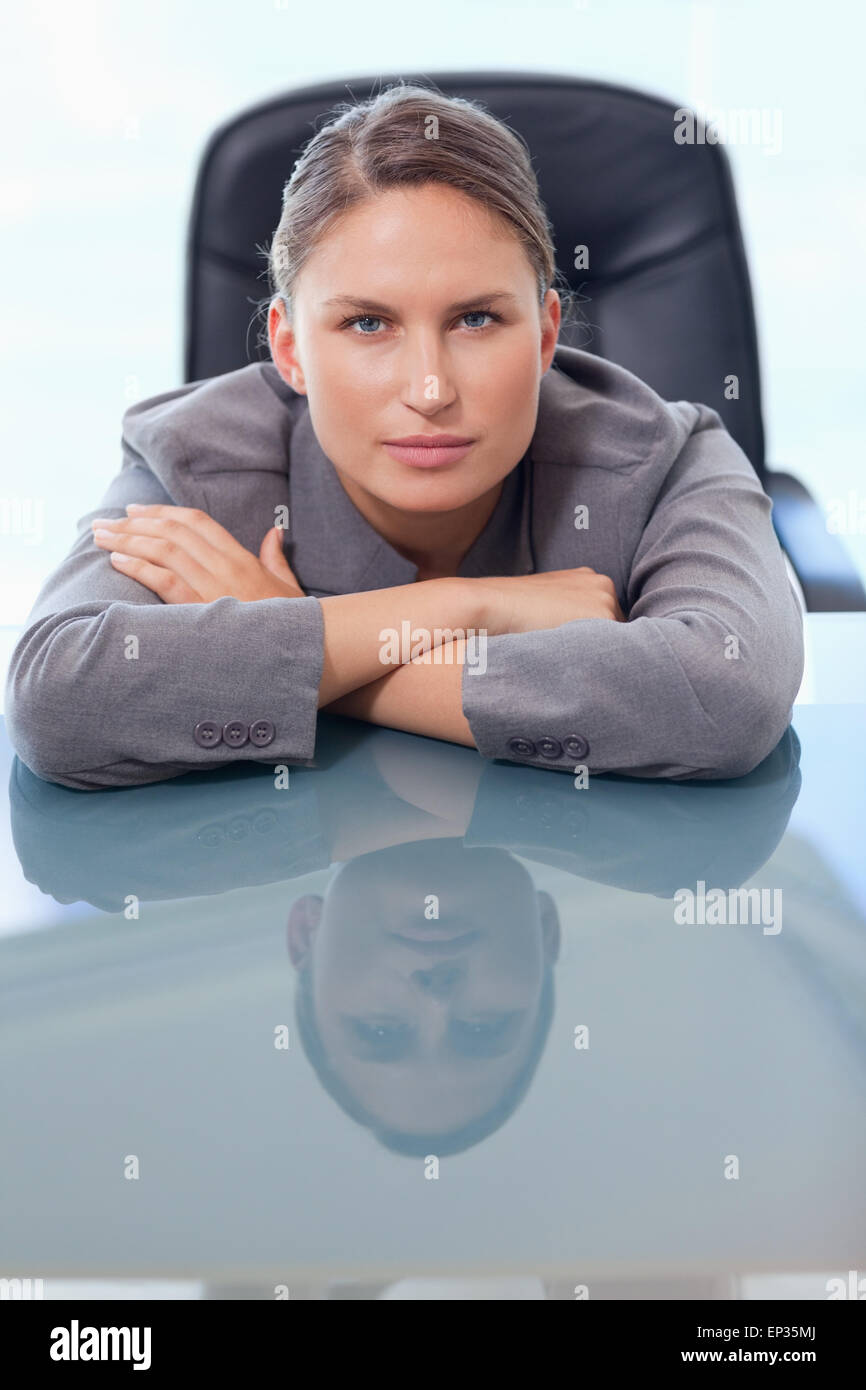 Portrait of a young businesswoman leaning on her desk Stock Photo - Alamy