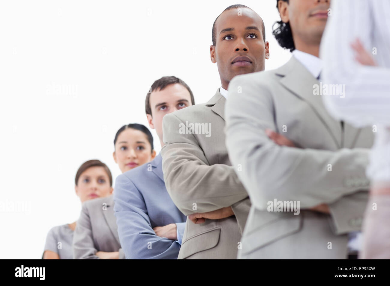 Low-angle shot of a serious business team crossing their arms in a ...