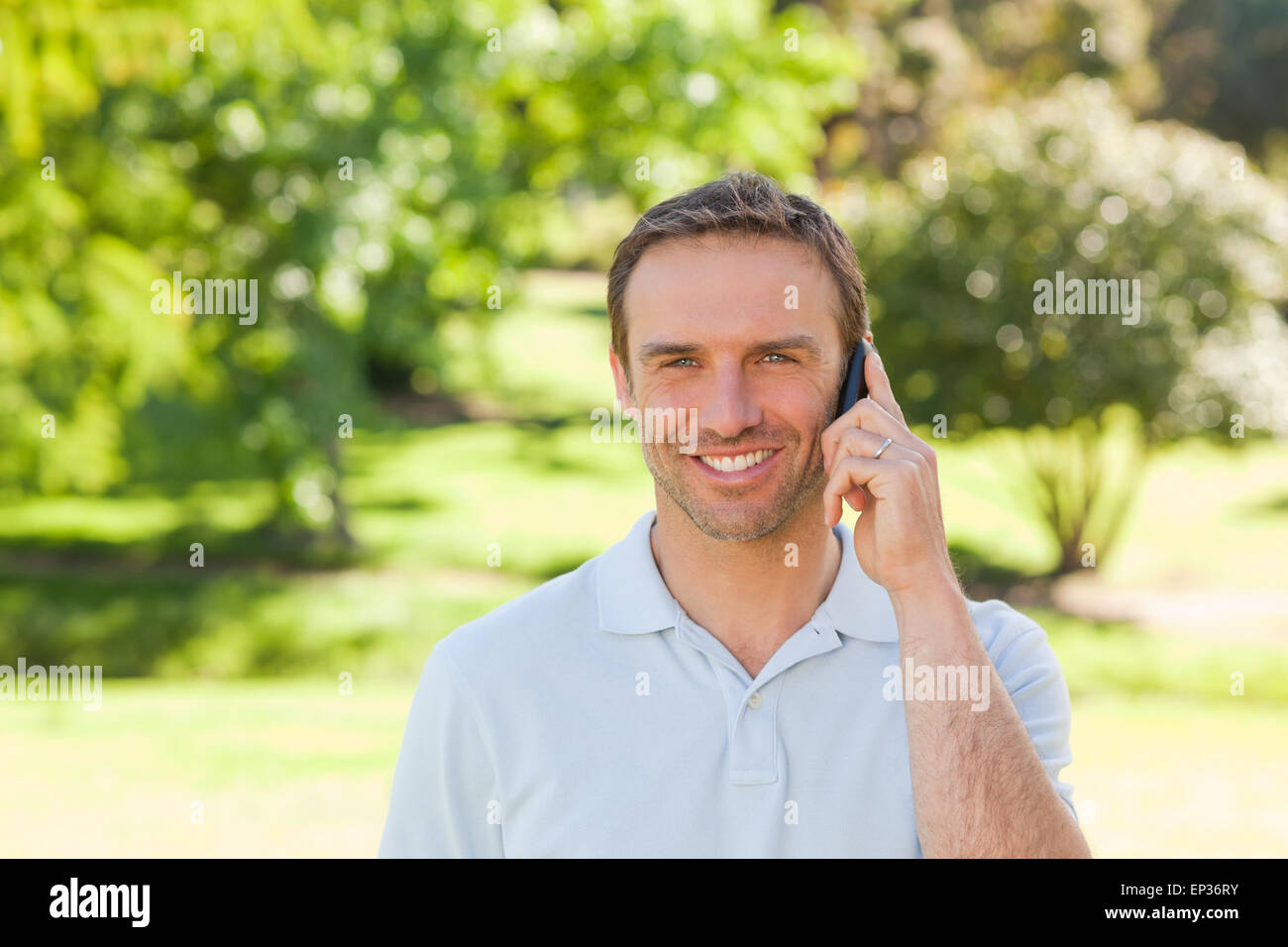 Handsome man phoning in the park Stock Photo - Alamy