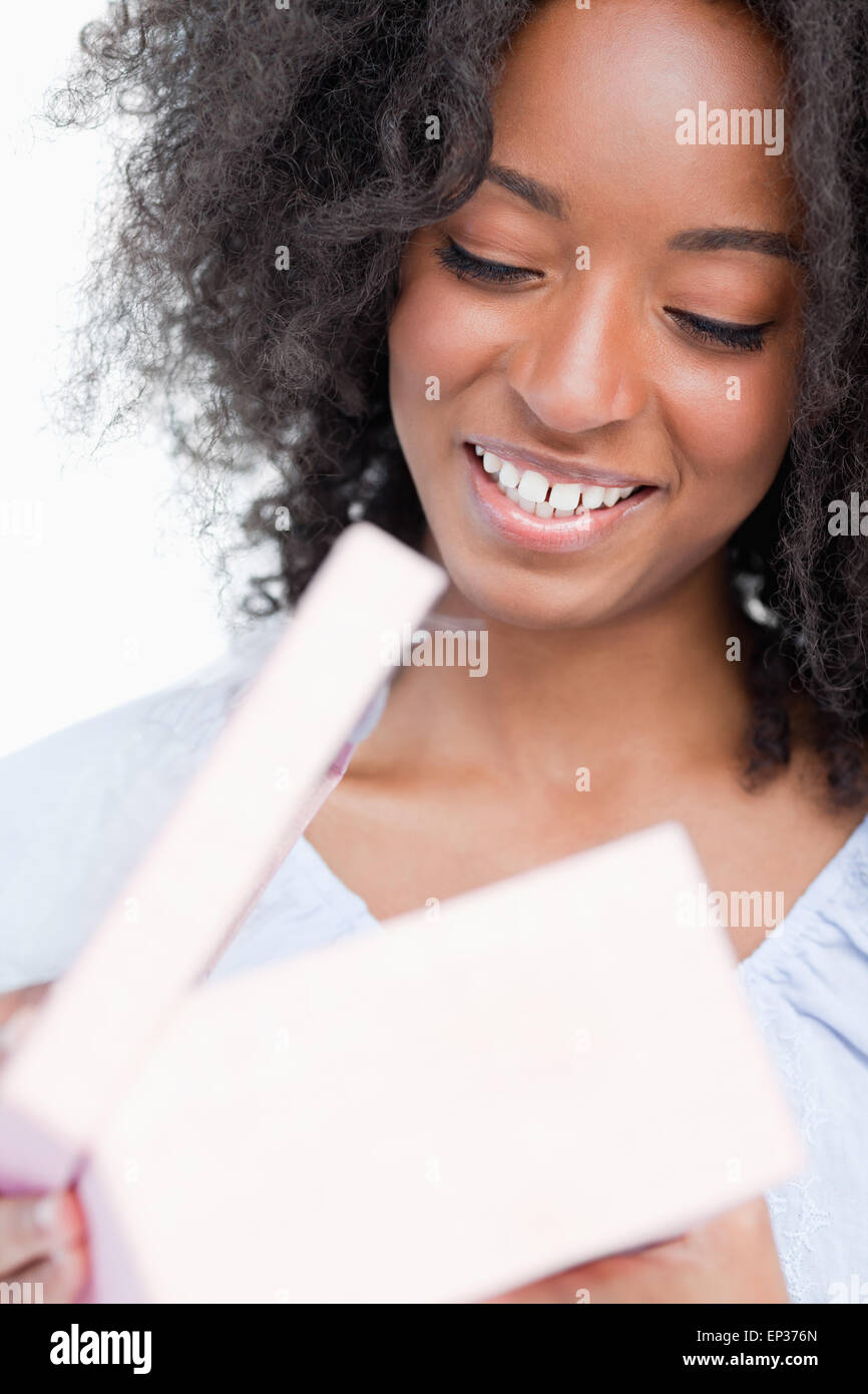 Young smiling woman joyfully opening her birthday gift Stock Photo - Alamy