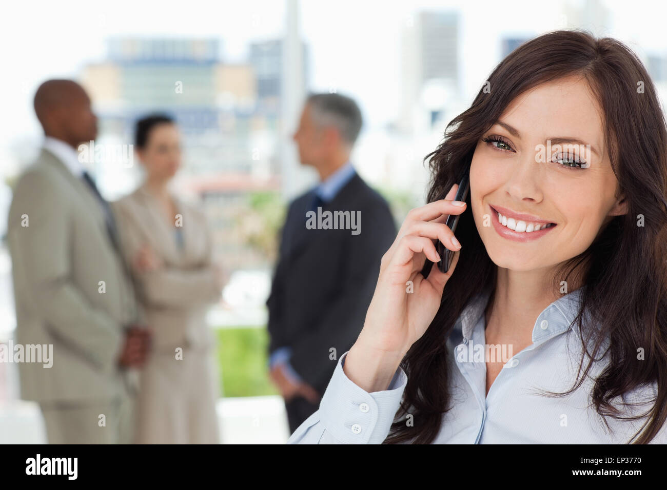 Young smiling businesswoman on the phone and tilting her head to one ...