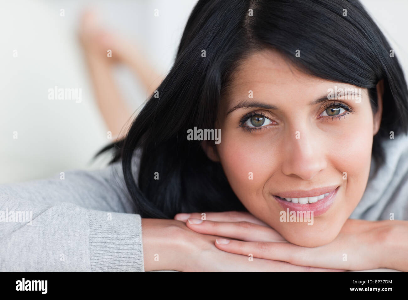Woman smiling as she holds her head with her arms Stock Photo - Alamy