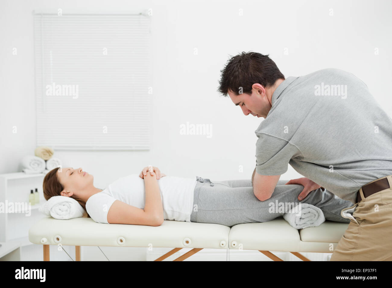 Woman lying on her back while being massaged by a man Stock Photo - Alamy