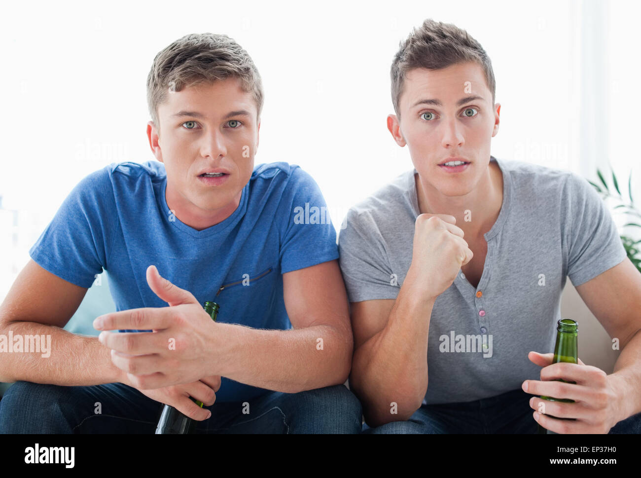 Two guys watching something as they look shocked Stock Photo - Alamy