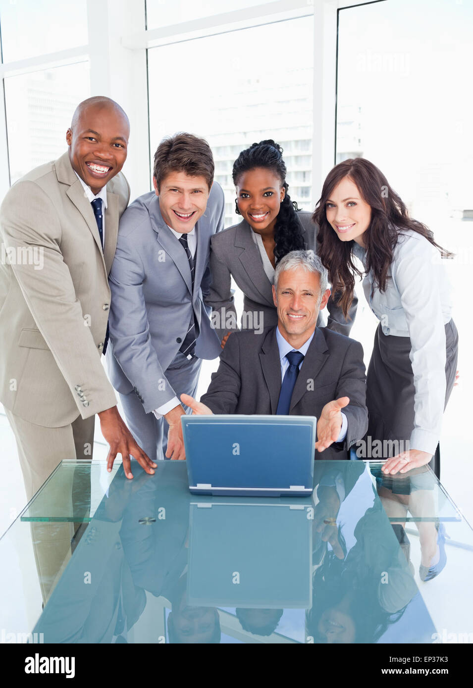 Four business people standing behind their manager proudly showing the ...