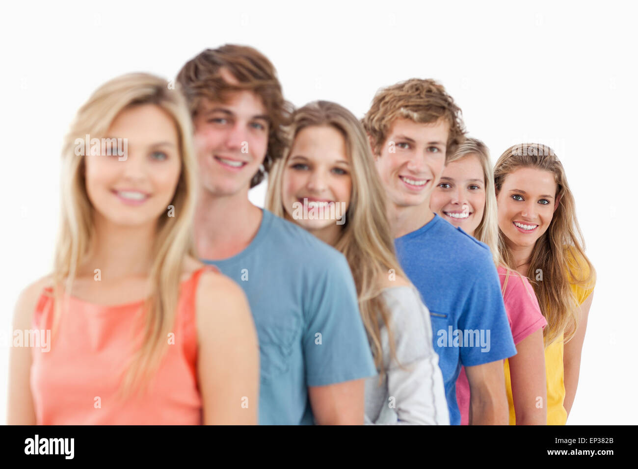 A smiling group standing behind each other at an angle Stock Photo - Alamy