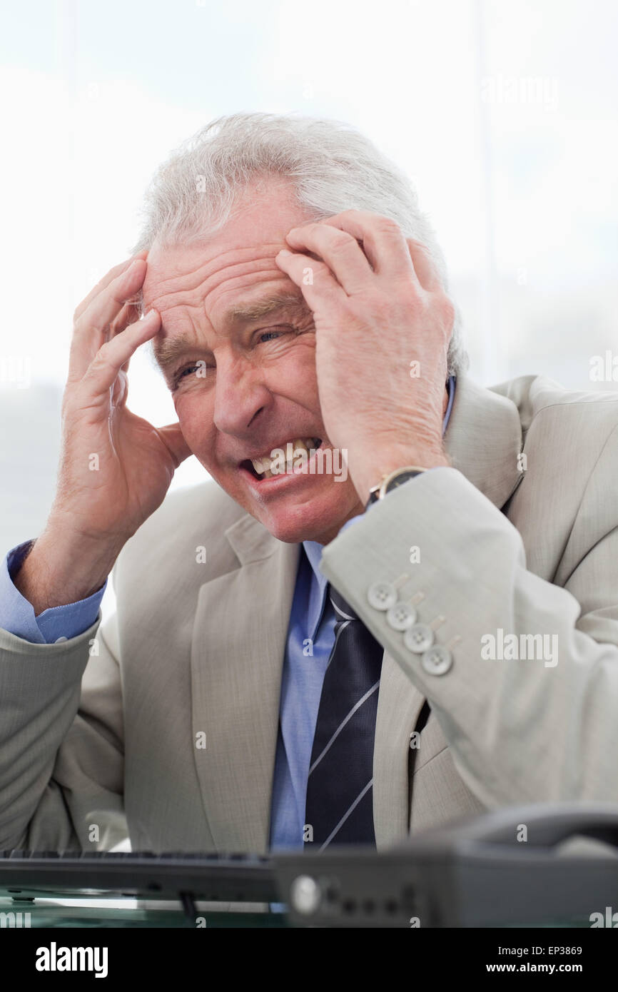 Portrait of a senior manager having a headache Stock Photo - Alamy