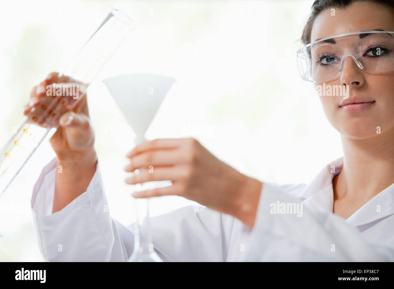 Scientist pouring liquid in a funnel Stock Photo - Alamy