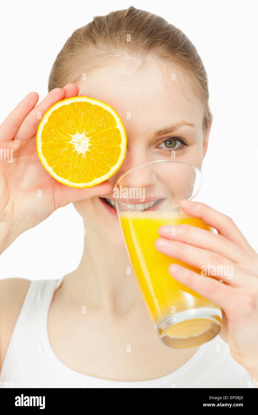 Woman placing an orange on her eye while drinking in a glass Stock ...