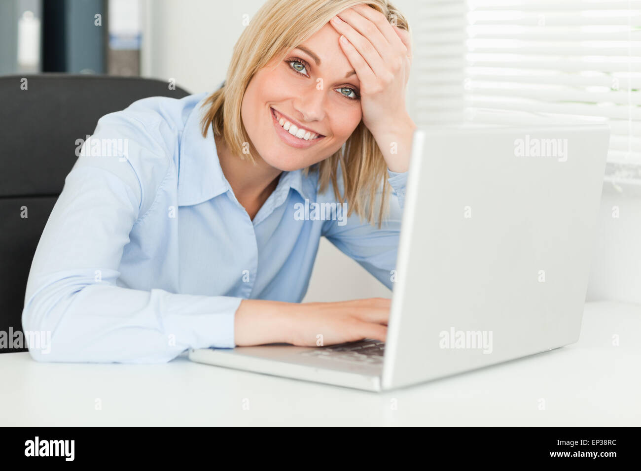 Blonde business woman touching her forehead Stock Photo - Alamy