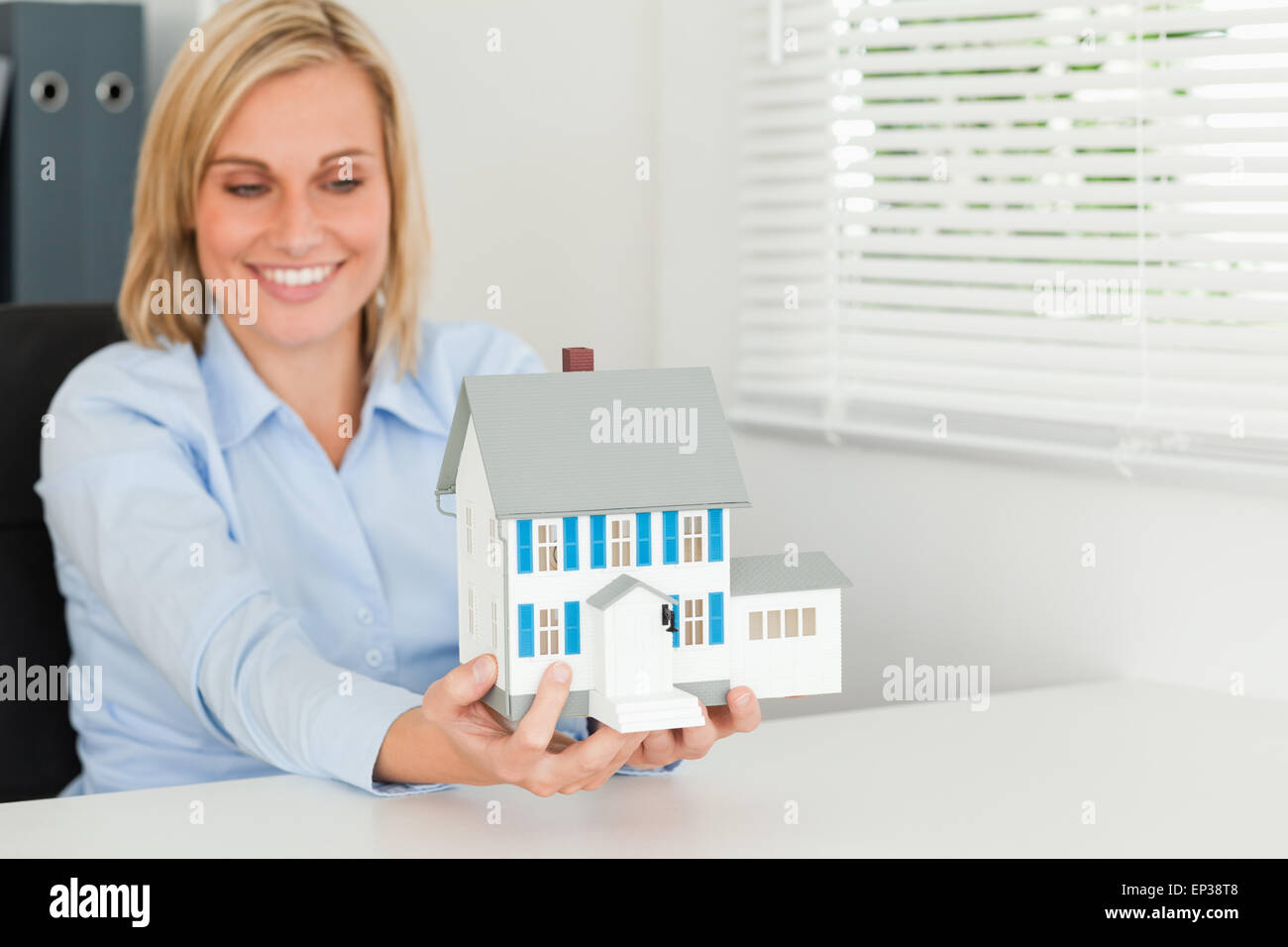Smiling woman showing model house Stock Photo - Alamy