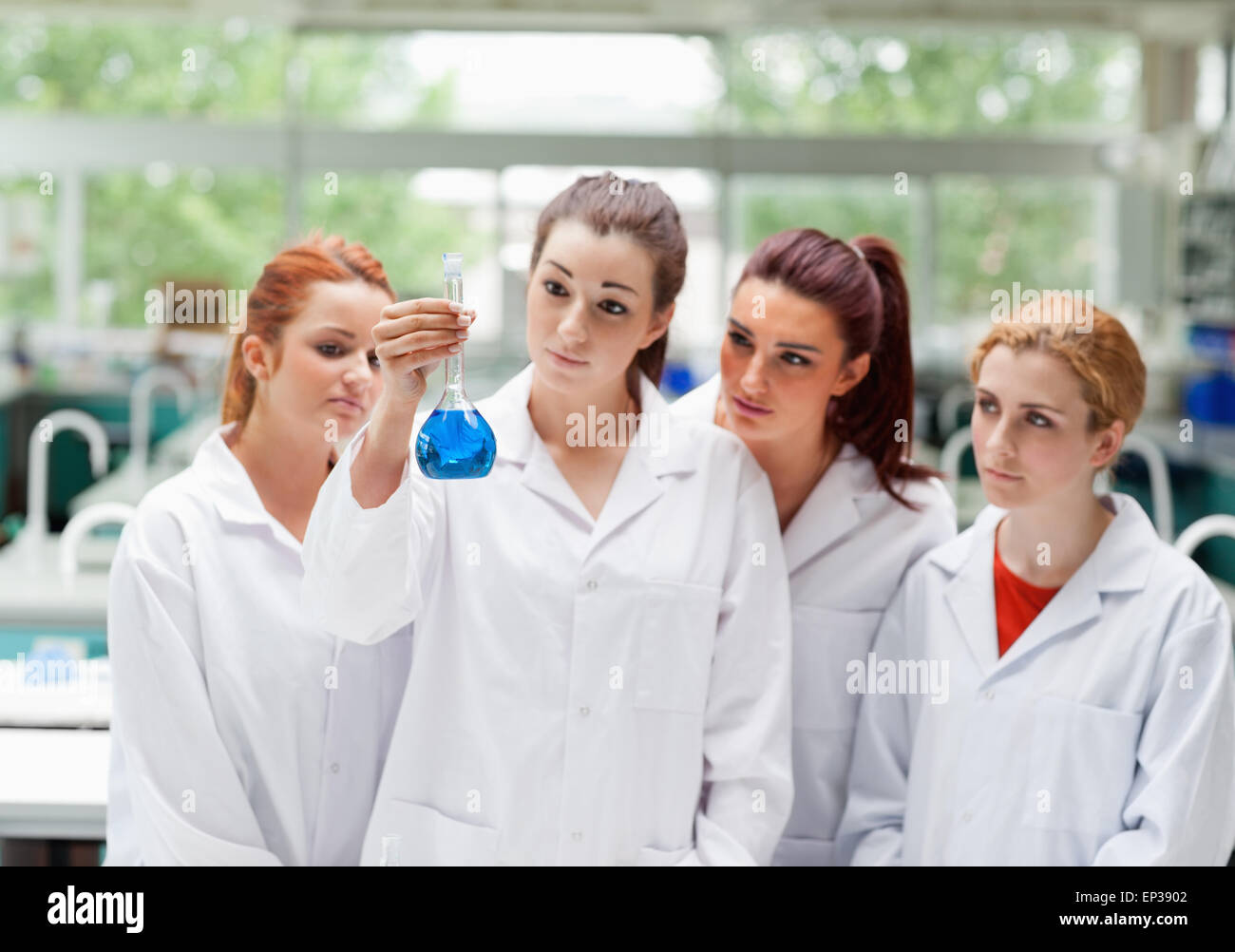 Cute science students looking at a flask Stock Photo - Alamy