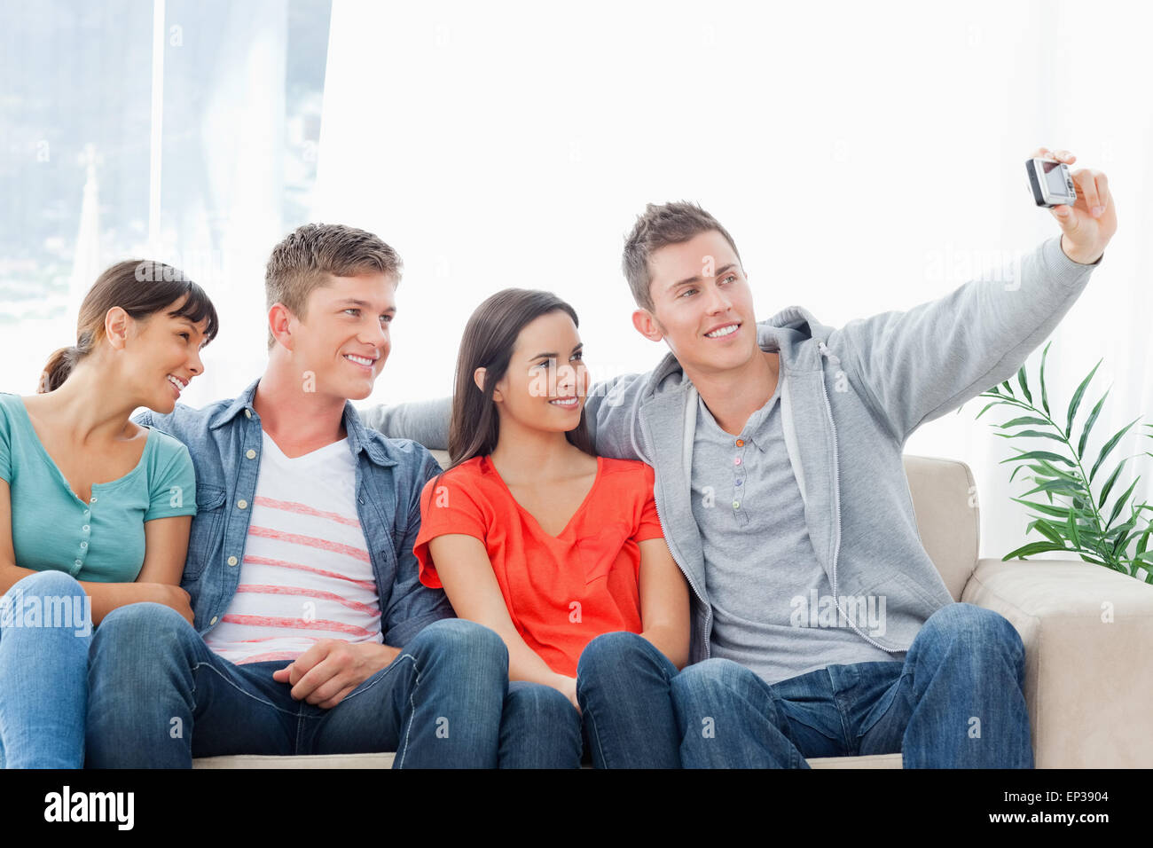 A group of friends pose for a photo while on the couch Stock Photo - Alamy