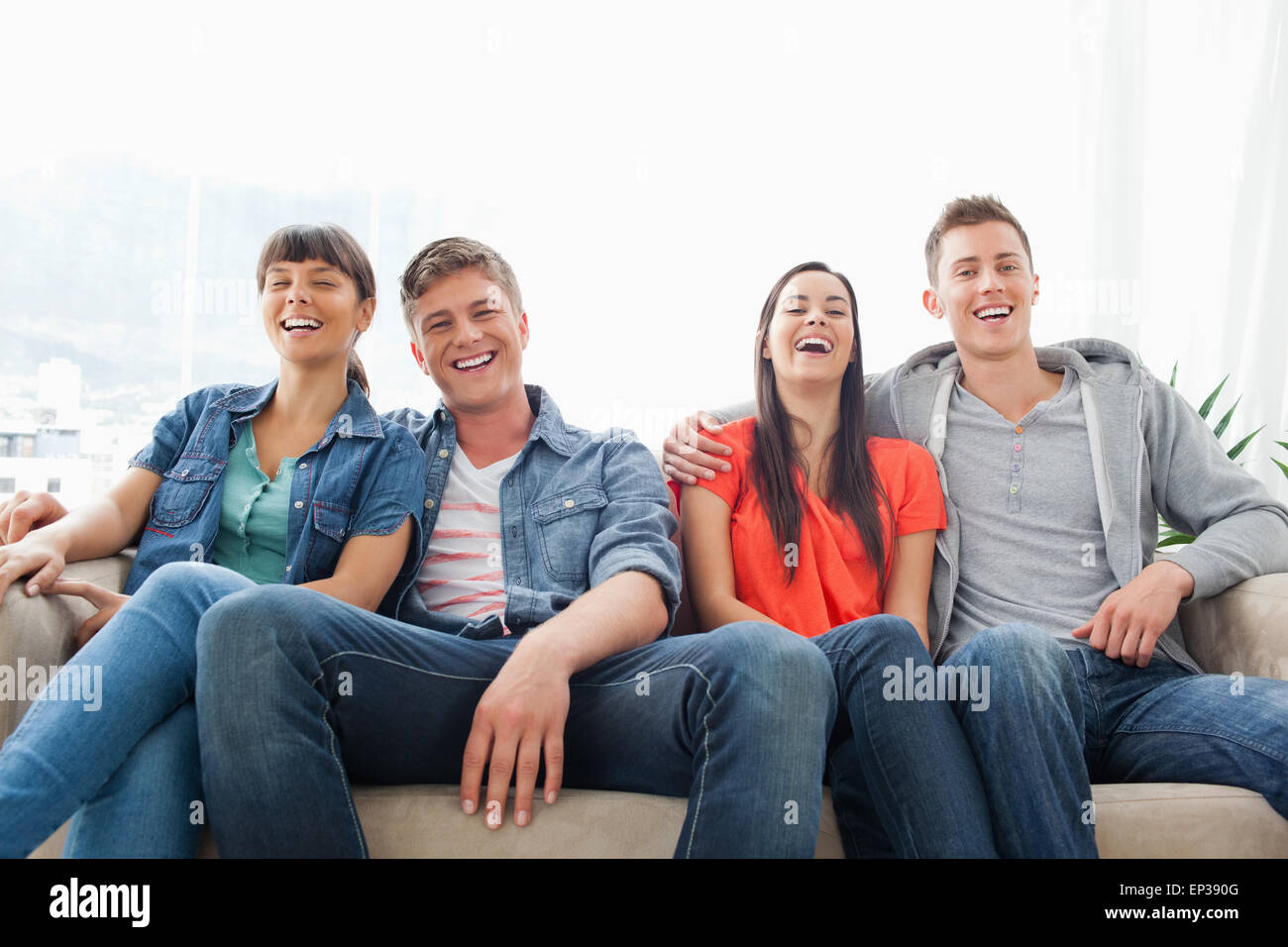 A group of laughing friends look into the camera Stock Photo - Alamy