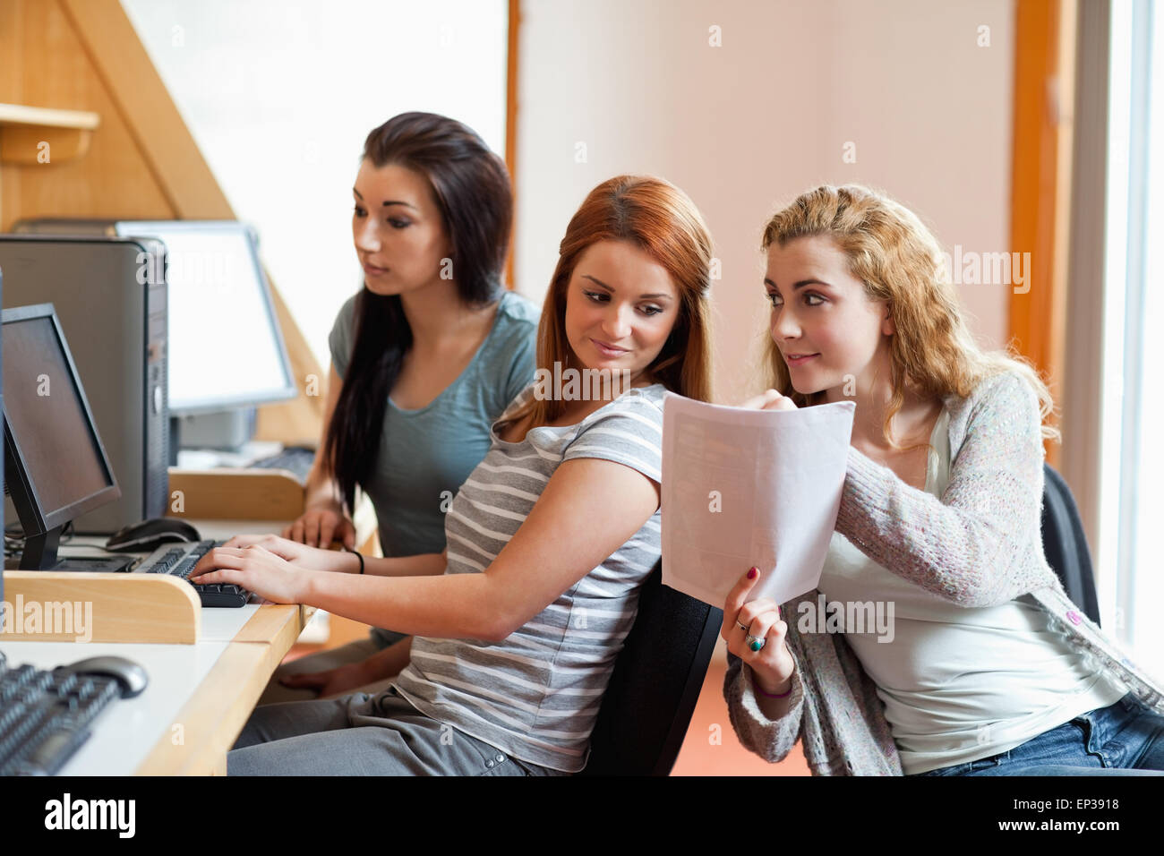 Cute student showing her notes to her classmate Stock Photo - Alamy