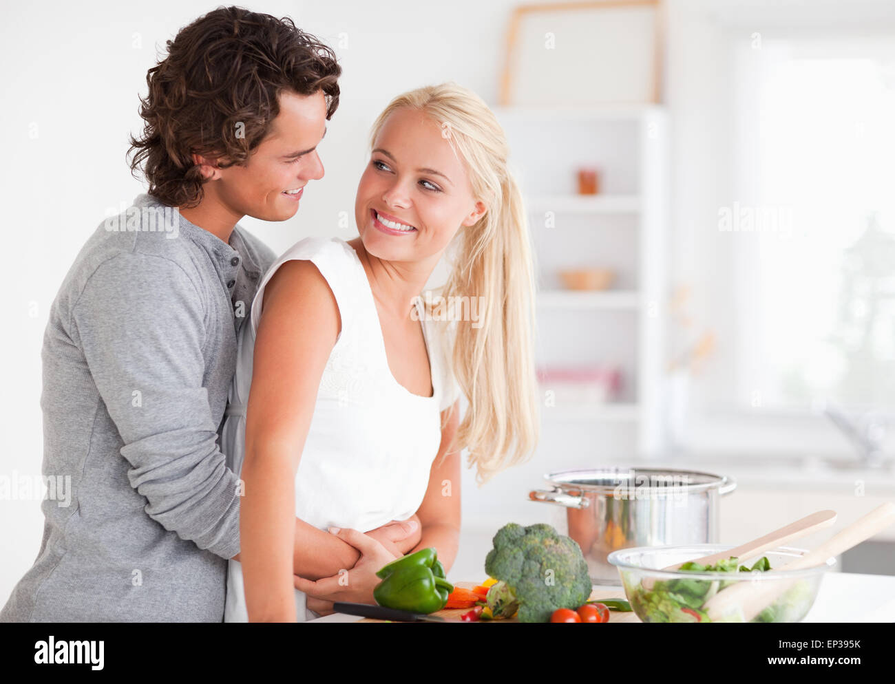 Lovely couple hugging while cooking Stock Photo - Alamy