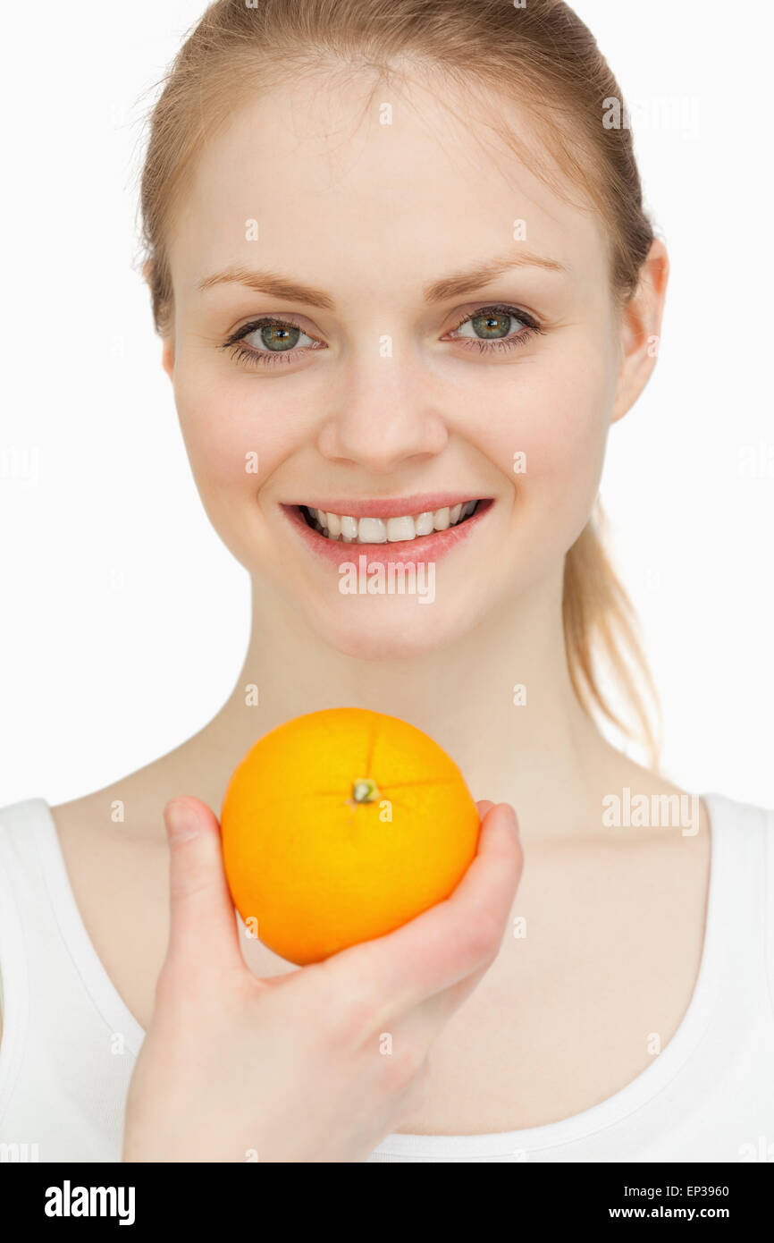 Close up of a woman presenting an orange while smiling Stock Photo - Alamy
