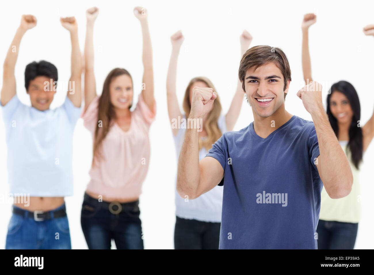 Man clenching his fists with people behind him raising their arms Stock ...