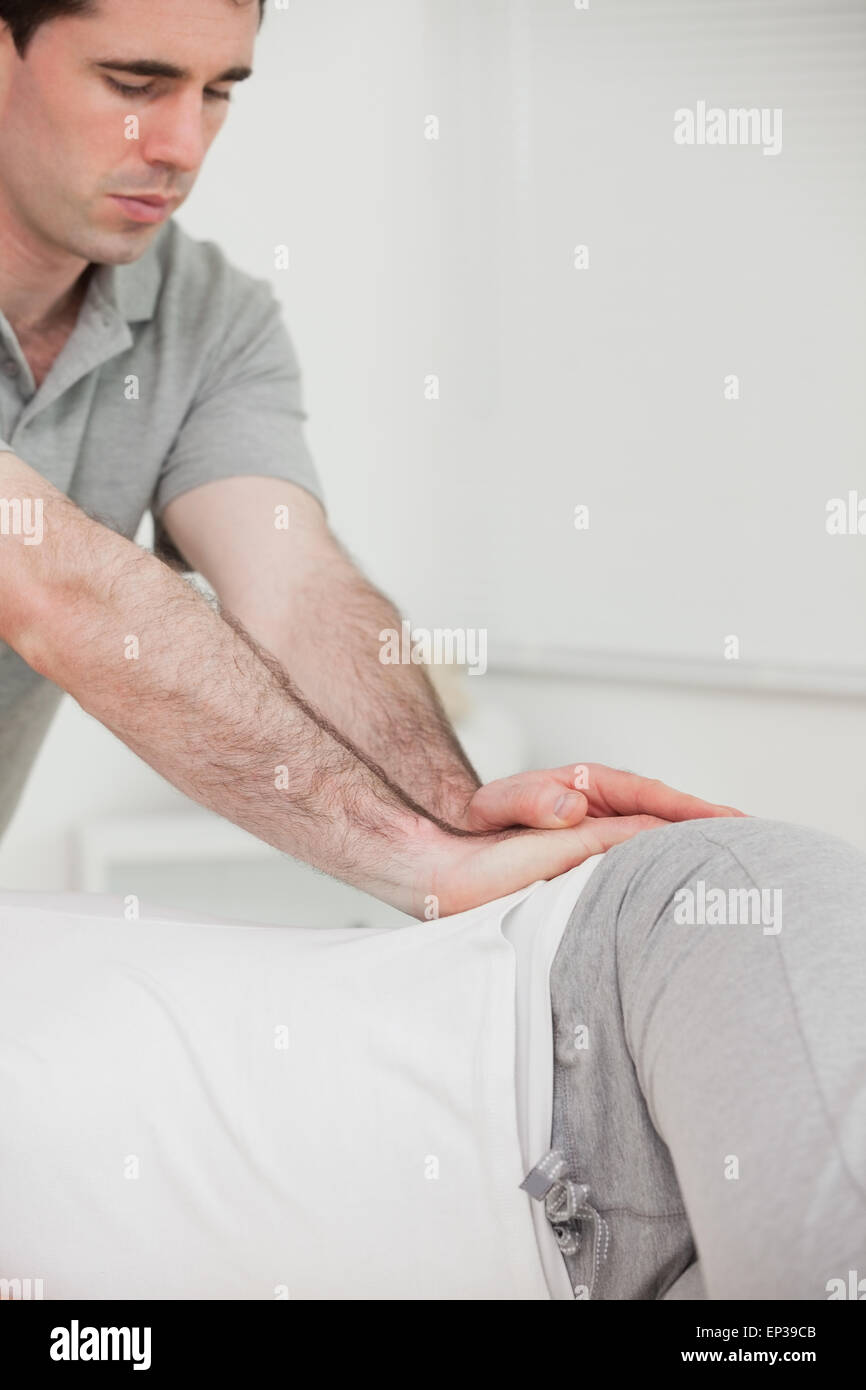 Serious chiropractor pressing the hip of his patient Stock Photo - Alamy