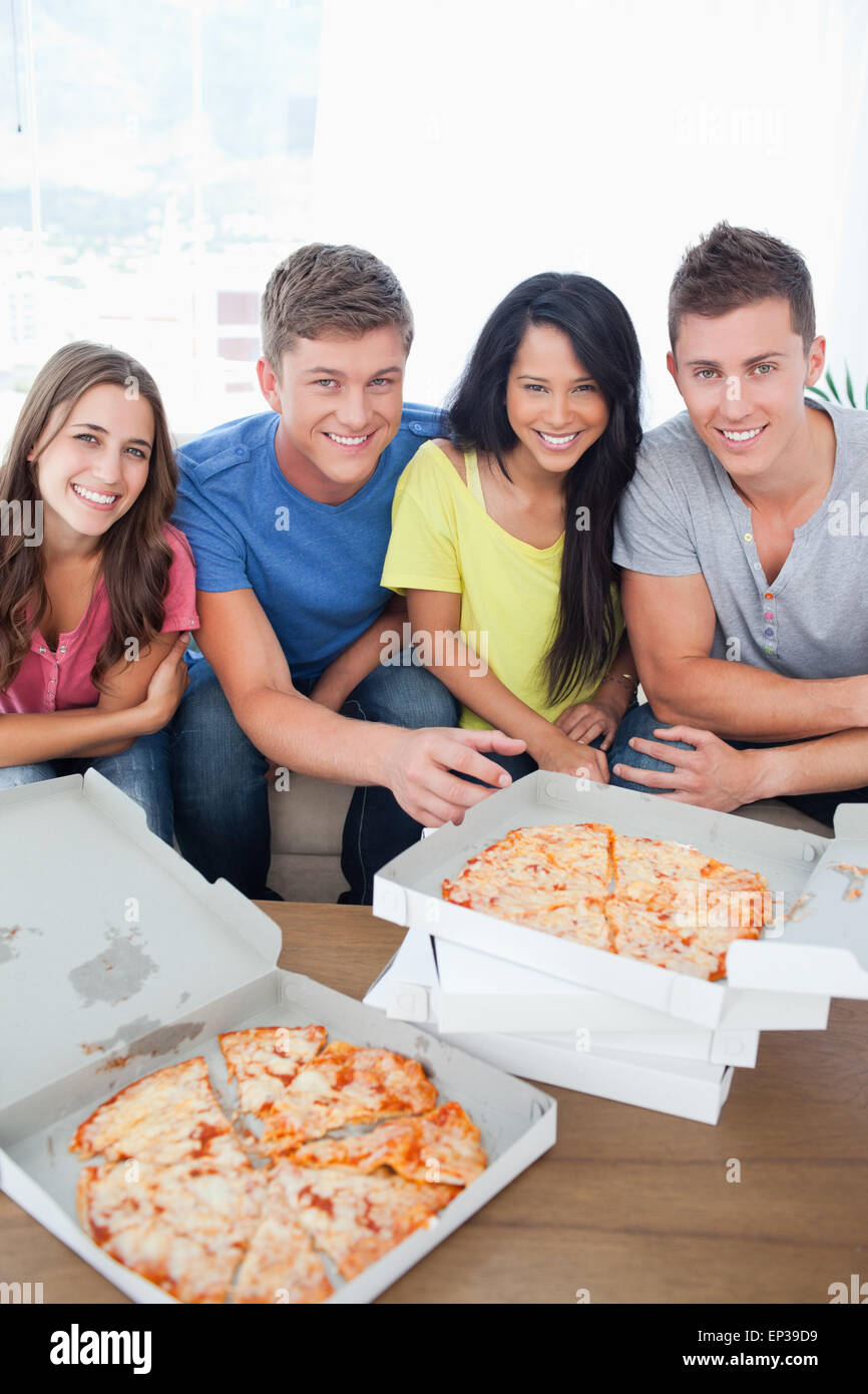 Friends sitting on a couch about to eat pizza Stock Photo - Alamy