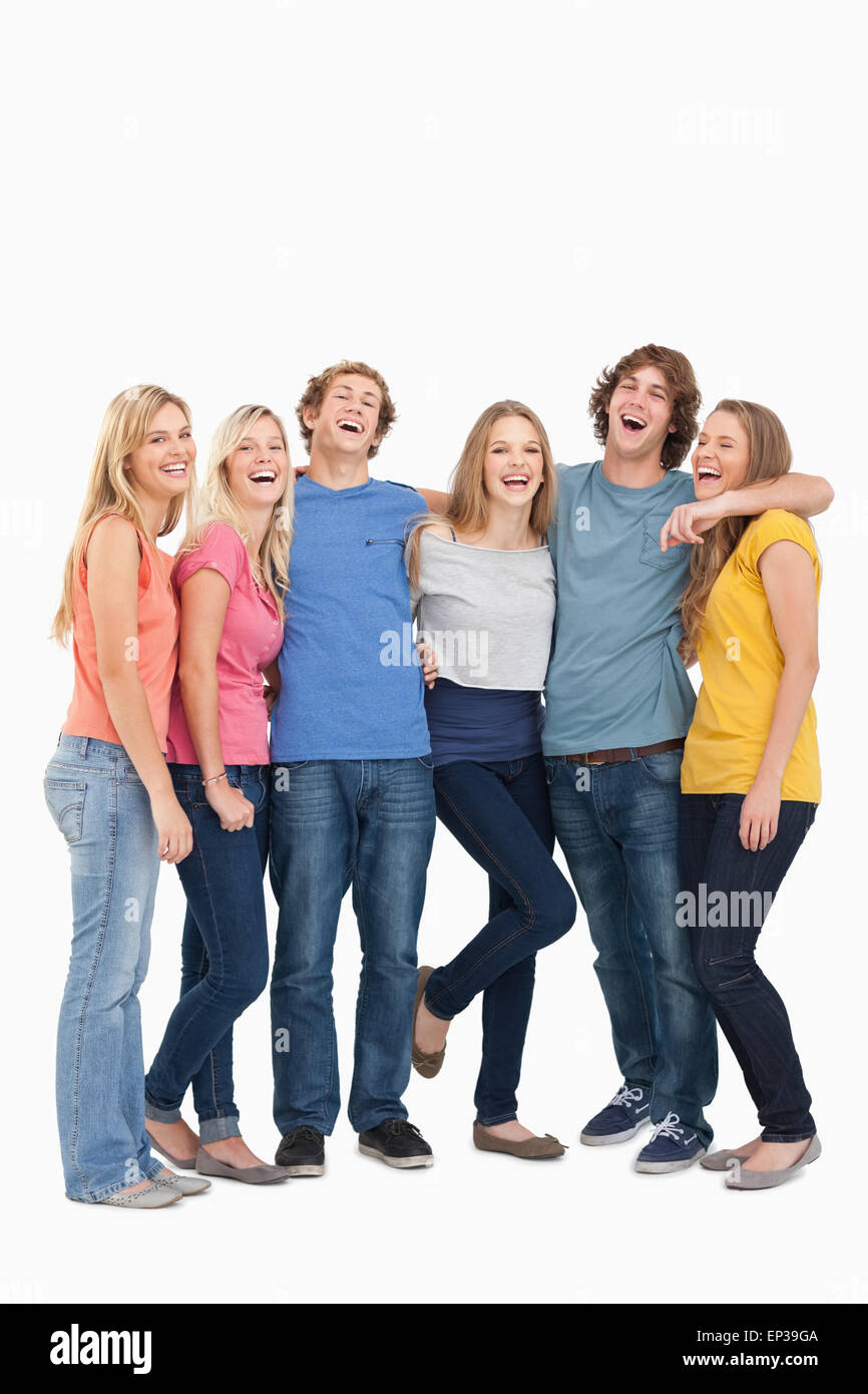 Full length of a group laughing together and looking at the camera ...