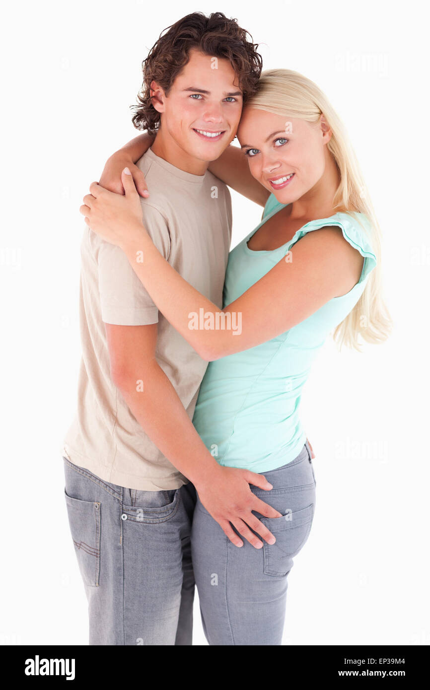 Hugging couple looking into the camera Stock Photo - Alamy