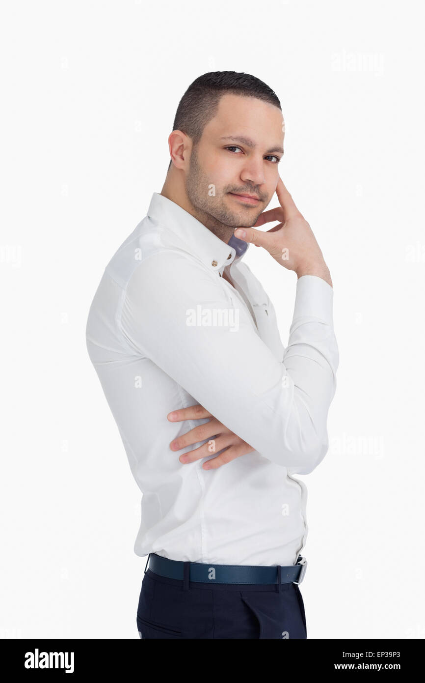 Man standing up while holding his chin with his hand Stock Photo - Alamy