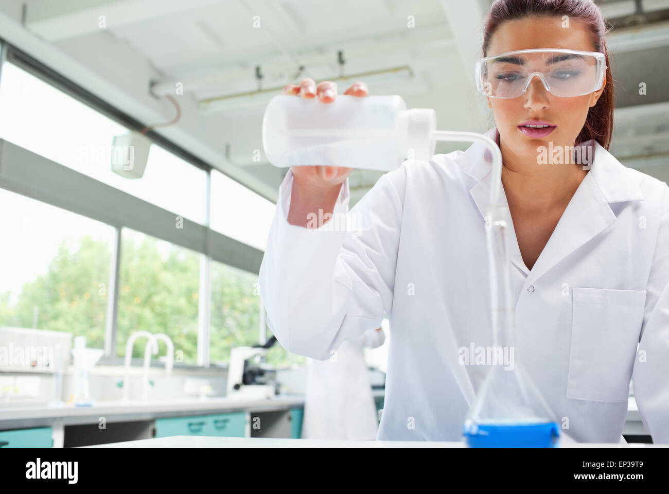 Female science student pouring liquid Stock Photo - Alamy
