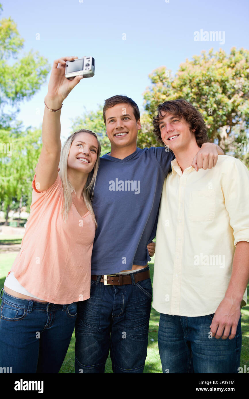 Three smiling friends taking a pictures of themselves Stock Photo - Alamy