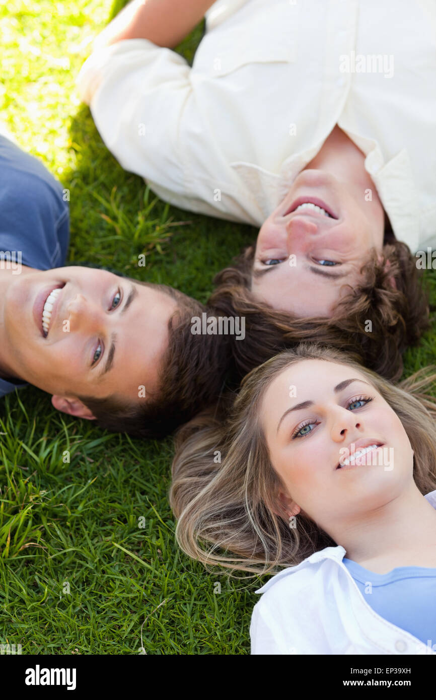 Three students resting together while looking at camera Stock Photo - Alamy